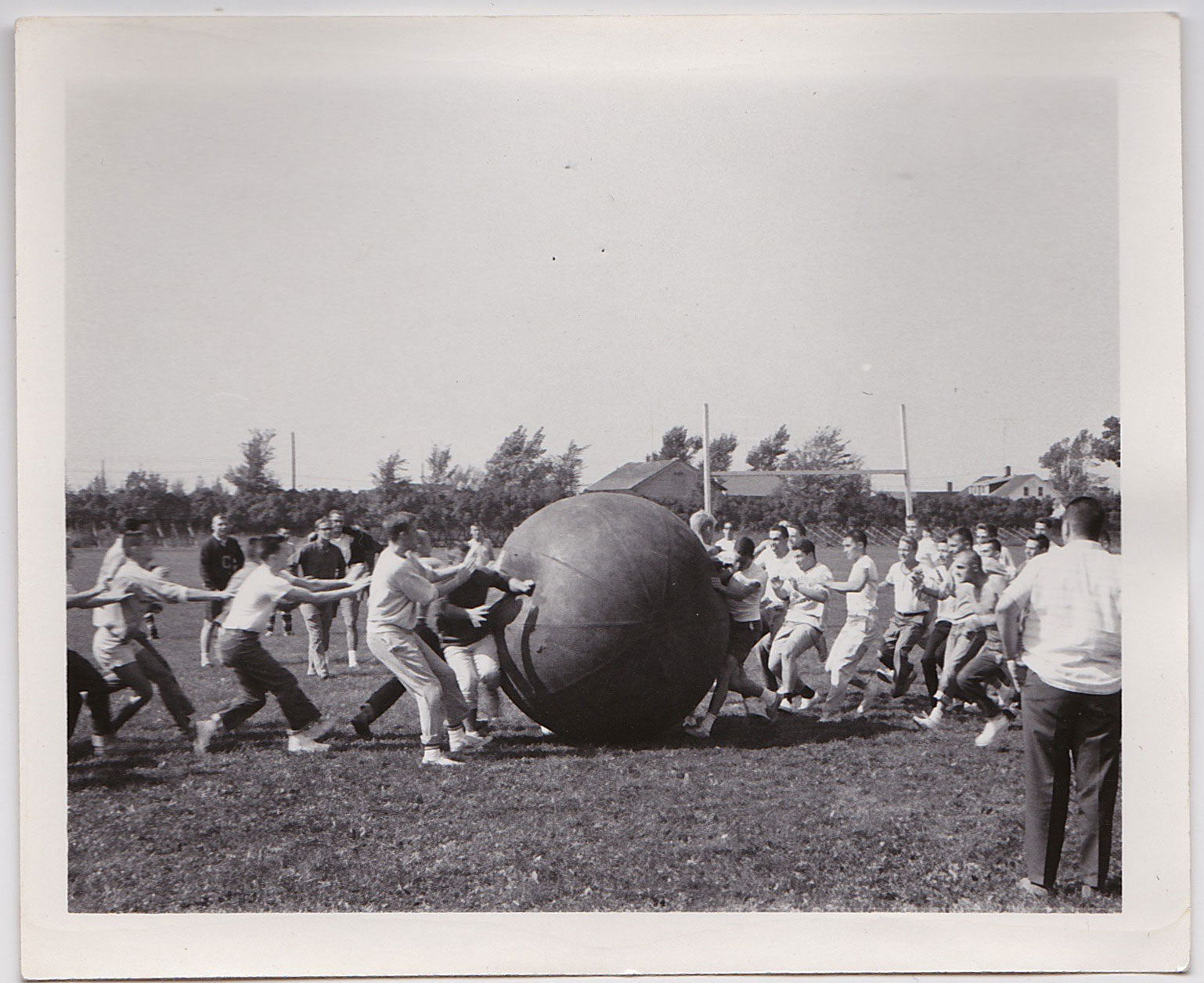Men Pushing a Giant Leather Ball – Homobilia